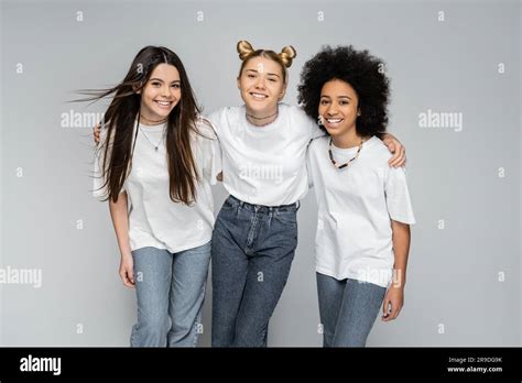 Chica Adolescente Rubia Sonriente En Camiseta Blanca Y Jeans Abrazando