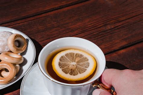 맛있는 음식과 과자와 함께 티 파티 세라믹 화이트 컵과 차 세트 레몬을 손에 들고 차 한 잔을 들고 있습니다 갈색에 대한 스톡 사진 및 기타 이미지 Istock