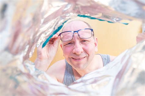 남자의 깜짝 얼굴은 눈을 가늘게 뜨고 또래 남자는 안경을 이마에 올려 가방을 바라본다 얼굴에 감정 패키지에서 볼 수 있습니다 45 49세에 대한 스톡 사진 및 기타 이미지