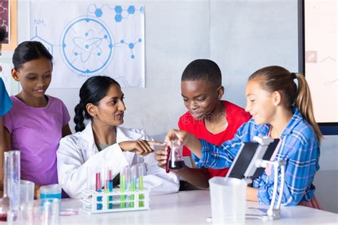 In School Indian Female Teacher And Students Conducting Science