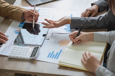 마케팅 재무 회계 기획 회사는 마케팅 담당자 팀이 노트북 컴퓨터 그래프와 계산기 및 태블릿을 사용하여 회사의 이익을 분석합니다 사업 개념 3 명에 대한 스톡 사진 및 기타