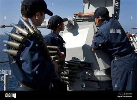 US Navy Sailors Load A Mk 38 Mod 2 25mm Machine Gun System Aboard
