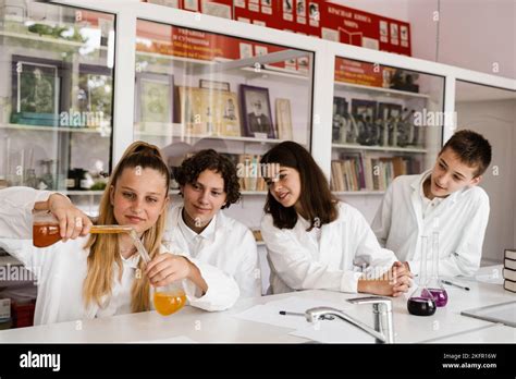 Chemistry Lesson Schoolgirl And Classmates Holds Flask For Experiments