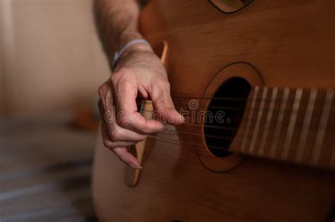 Male Hands Of An Elderly Senior Caucasian Man Holding And Playing A