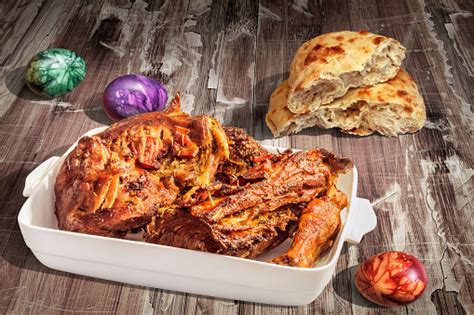 갓 침을 볶은 전통 발효 된 Flatbread와 함께 양고기 어깨와 손으로 그린된 부활절 달걀에 옻 칠한 소박한 옛 풍 화 금이