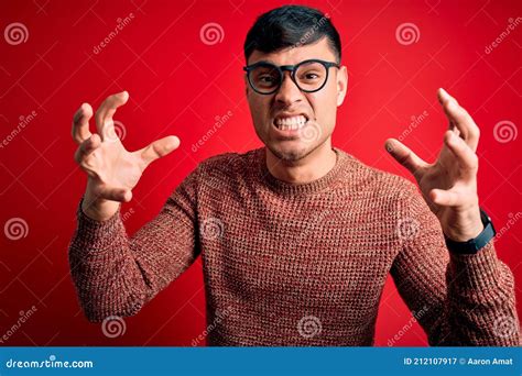 Young Handsome Hispanic Man Wearing Nerd Glasses Over Red Background Shouting Frustrated With