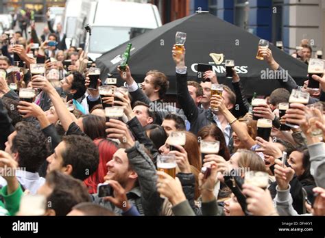 Image People In A Crowd Holding Pints Of Guinness In The Air During The