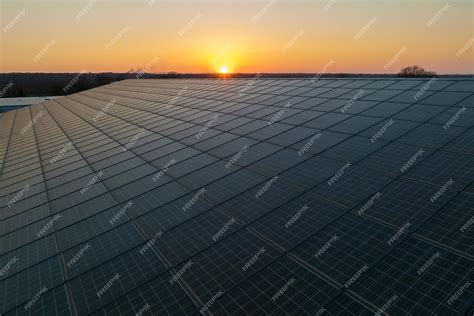 Вид с воздуха на синие фотоэлектрические солнечные панели установленные на крыше промышленного