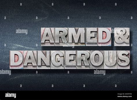 Armed And Dangerous Phrase Made From Metallic Letterpress On Dark Jeans