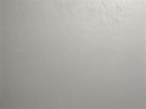 Premium Photo A White Wall With A Small Speck On It