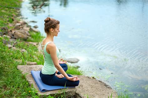 요가 레슨을 연습 요가 여자 호흡 명상 운동 아르다 Padmasana 물 배경에 대 한 자연에 여름에 클로즈업 무드라 제스처와 반 연꽃 포즈 가냘픈에 대한 스톡 사진 및