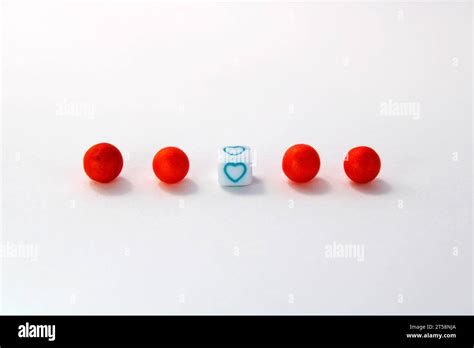 Row Of Red Spheres And A Cube In The Center With A Heart Figure That Makes A Difference Stock