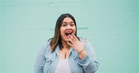 야외에서 하늘색 벽에 기대어 서 있는 동안 충격을 받은 표정을 가진 젊은 플러스 사이즈 여성의 초상화 사진 Unsplash의 몸짓 이미지