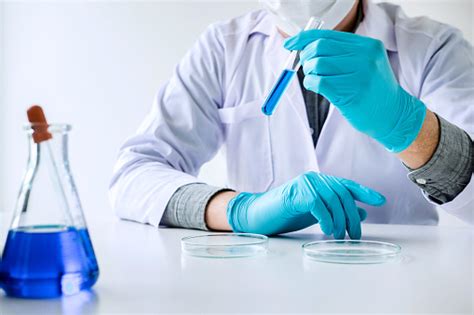 생화학 실험실 연구 과학자 또는 의료 실험실 코트 유리 장비 실험실에서 일을 통해 색상 액체의 방울 시 약 테스트 튜브를 잡고