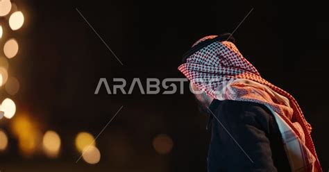 زاوية من الخلف لرجل عربي خليجي سعودي ، يرتدي الزي السعودي التقليدي