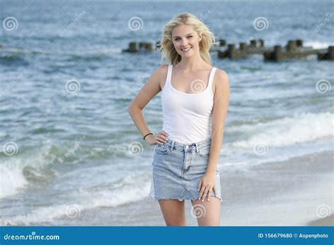 Uma Jovem Loira Espantosa Na Praia No Topo Do Tanque Branco Foto De Stock Imagem De Fofofo