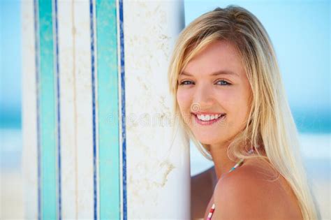 Enjoying The Moment Portrait Of A Pretty Blonde With Her Surfboard On