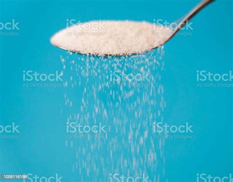 설탕 스트림에 숟가락에서 부 어 되 고 고립 너무에 파란색 배경에 많은 설탕 달콤한 중독 당뇨병 질병 건강에 해로운 식품 개념 0명에 대한 스톡 사진 및 기타 이미지