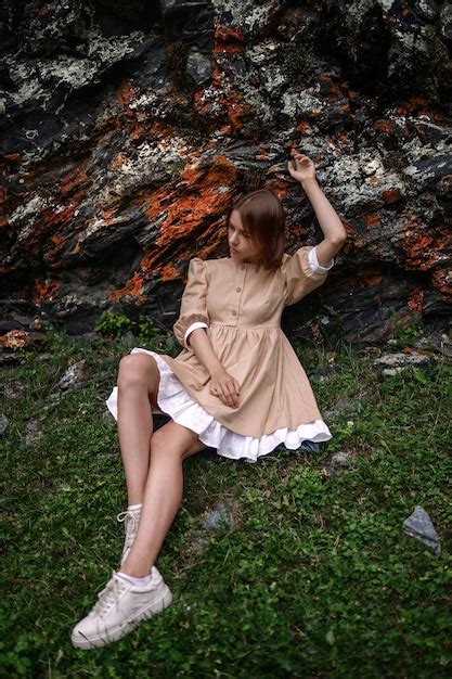 Premium Photo Beautiful Brunette Woman Sits On The Grass And Poses