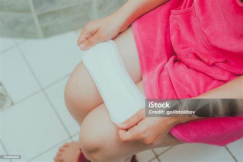 생리대와 화장실에서 여자입니다 어린 소녀는 화장실에 앉아 있는 동안 위생 패드를 보유 하 고 있습니다 월경에 대한 스톡 사진 및 기타 이미지 Istock