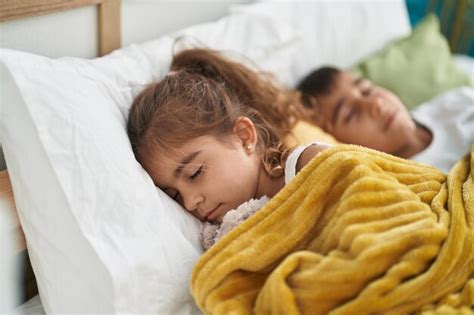 Frère Et Soeur Allongés Sur Le Lit Dormant Dans La Chambre Photo Premium