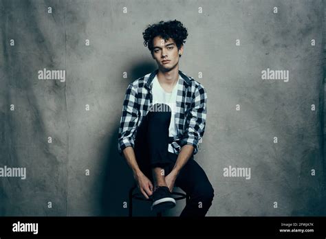 Guy Sitting On A Chair Curly Hair Plaid Shirt Fashion Lifestyle Stock