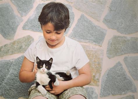 niño feliz jugando con gatito Foto de stock en Vecteezy