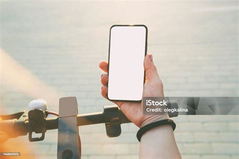 전기 스쿠터를 들고 서서 빈 흰색 화면으로 전화기를 보여주는 소녀 거리에 대한 스톡 사진 및 기타 이미지 거리 공란 도시