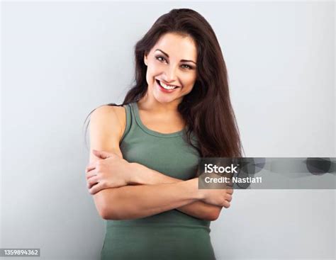 빈티지 컬러 배경에 녹색 티셔츠에 접힌 강한 팔로 몸을 껴안고 있는 아름다운 캐주얼한 귀여운 이빨 미소 여자 클로즈업 세로 한 명의 여자만에 대한 스톡 사진 및 기타 이미지