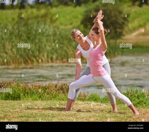 Feeling The Stretch A Young Woman Being Instructed In An Outdoor Yoga