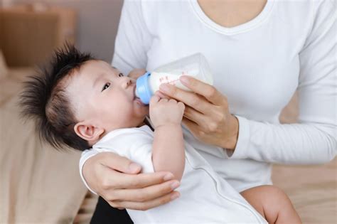 Madre Alimentando Al Bebé Con La Botella De Leche Foto Premium
