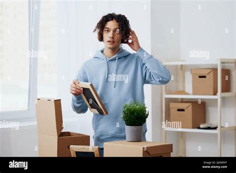 Portrait Of A Man Unpacking Things From Boxes In The Room Sorting