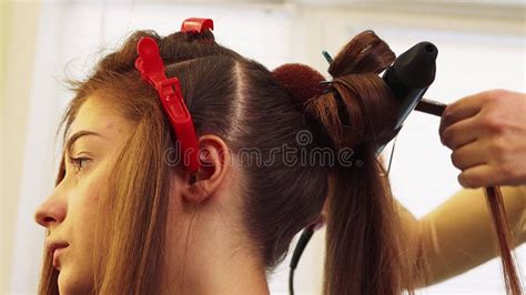 On The Head Of A Girl In Profile A Curl Is Made With Electric Tongs