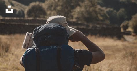 검은 티셔츠를 입고 검은 배낭을 메고 낮 동안 갈색 잔디밭에 서 있는 남자 사진 Unsplash의 무료 하이킹 이미지