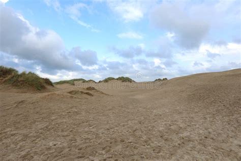 Sand Dune And Vegetation With Blue Sky And White Clouds Stock Image