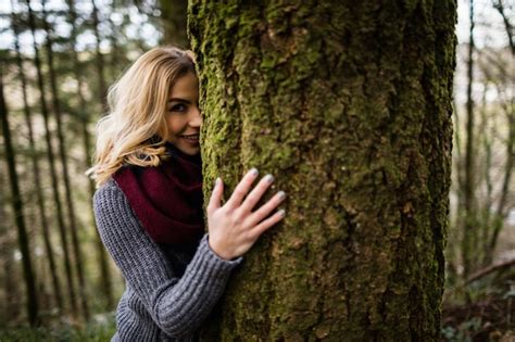 Premium Photo Beautiful Woman Hiding Behind Tree Trunk In Forest