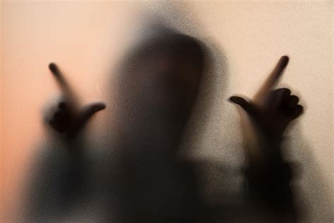 공포와 후드 자 켓 남자의 그림자 부분 유리에 손입니다 젖 빛된 유리 뒤에 위험한 남자입니다 미스터리 남자입니다 할로윈