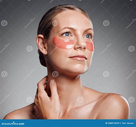 Beautiful Mature Woman Posing With Under Eye Patch In Studio Against A