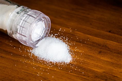 핑크 화이트 천연 유기농 히말라야 바다 소금 분말 플레이크 와 향신료 Peper 칠리 쿡 성분을 분쇄기 병 유리에 빈티지 소박한 검은 주방 나무 테이블에 닫습니다 소금