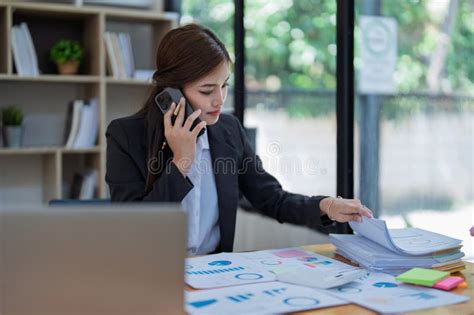 Professional Businesswoman Engaged In Smartphone Call By Calculator To