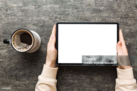 커피 한 잔과 함께 문자 메시지 또는 홍보 콘텐츠 옴 테이블에 대한 빈 복사 공간 화면이 있는 디지털 태블릿을 들고 있는 이미지 여자 손을 닫습니다 빈 태블릿 장치를 들고