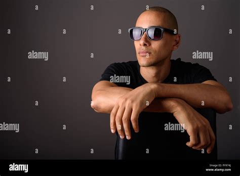 Portrait Of Handsome Bald Man Sitting On Chair And Wearing Sunglasses