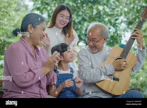 Asian Senior Elderly Man Or Grandfather Playing Guitar While His