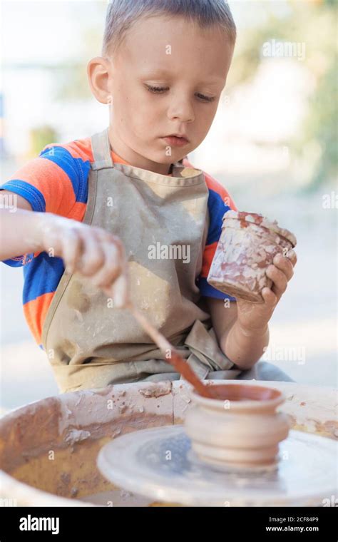 Hands Of Young Potter Creating An Earthen Jar On The Circle Close Up