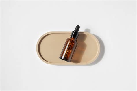 타원형 연단에 호박색 유리 점적기 화장품 병 흰색 배경 천연 스킨 케어 Spa 디자인 미네랄 유기농 오일 모형 기름진 피펫 플랫 레이 상단보기 제품 프리젠 테이션 아로마오일