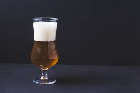 검은 색 배경에 수제 맥주와 거품 맥주 유리 튤립 그레인 보리 창백한 맥아에서 양조하는 수제 맥주가 가공됩니다 에일 또는 라거