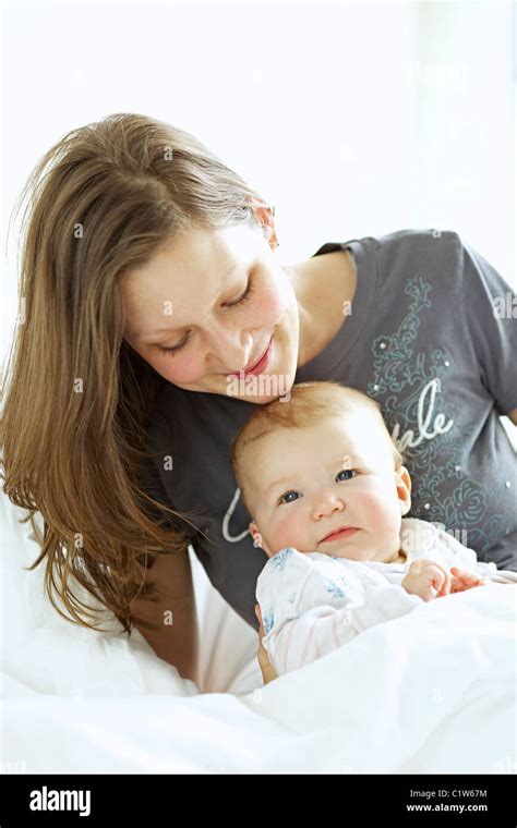 Portrait Of A Happy Mother Hugging Her Baby While Relaxing In Bed Stock Photo Alamy