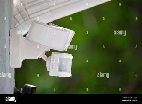 Motion Sensor With Light Detector Mounted On Exterior Wall Of Private