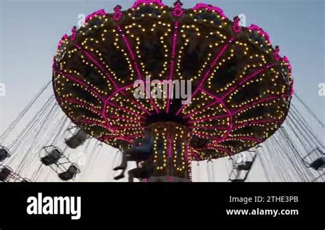 The Chain Carousel Spins In A Circle Amusement And Recreation Park People Sit Spinning On A