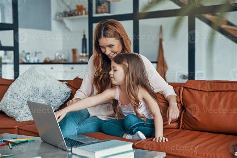 liebevolle schöne mutter und ihre kleine tochter verbinden sich und lächeln während sie zu